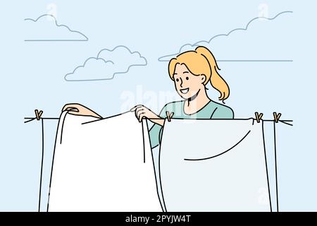 Smiling housewife hanging wet clothes outdoors Stock Photo - Alamy