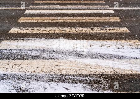 Snow, ice, and winter mud at a pedestrian crossing. The air temperature ...