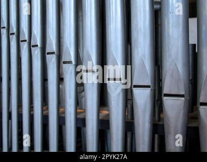 Many organ pipes stand side by side in an organ over a bellows Stock ...