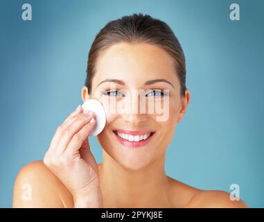 Young woman removing makeup with cotton pad on beige background Stock ...