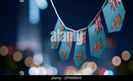 A garland of Fiji national flags on an abstract blurred background ...