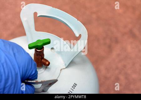 A Freon gas cylinder filled with colorless gas at room temperature ...