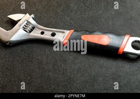 Tools, handcraft, do-it-yourself: Wrench, cropped against dark ...