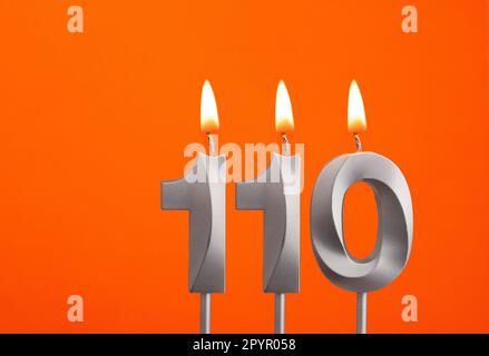 Candle number 110 - Birthday in blues foamy background Stock Photo - Alamy