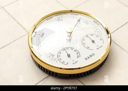 Aneroid barometer on white tiled background Stock Photo - Alamy