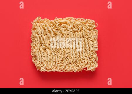 Raw instant noodles on red background Stock Photo - Alamy