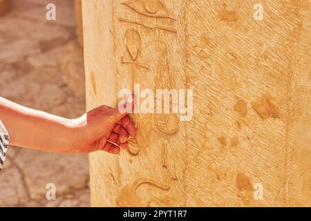 Image of hand touching Egyptian hieroglyphs in Mortuary Temple of ...