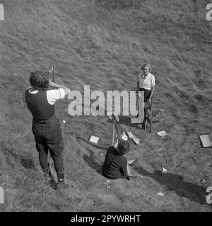 Three women are practicing shotgun shooting. While one of them is ...