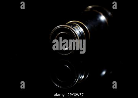 small vintage mono ocular spyglass on black surface with black background Stock Photo - Alamy