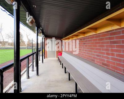 Brick baseball dugout with concrete floor, benches and protective ...