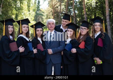 University professor and seven graduates rejoice at graduation Stock ...