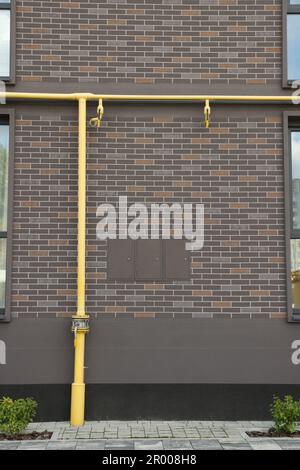 Gas distribution system with pipes near red brick wall outdoors Stock ...