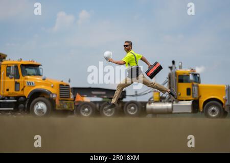 Middle aged builder excited jump on site construction. Excited builder ...