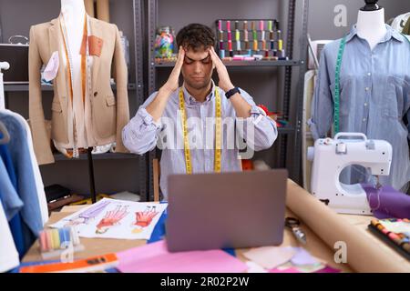 Young hispanic man dressmaker designer using smartphone smiling happy ...