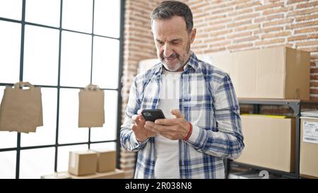 Middle age man ecommerce business worker using smartphone writing on ...