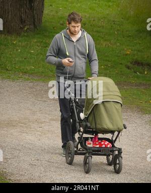 A man walks with a baby carriage in the street. (Photo by Kristian ...