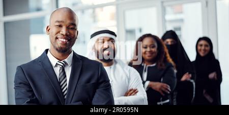 Happy young businessman lining up a ball with his cue during a game of ...
