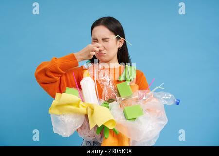 Disgusted asian woman, holds stinky garbage, recycling her waste with ...