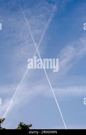 Blue sky with aeroplane smoke crossing Stock Photo - Alamy