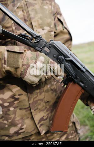 Military man holding AK-47 with tactical gloves closeup Stock Photo - Alamy