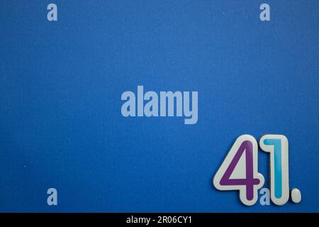 The number 41, placed on a blue background, photographed from above ...