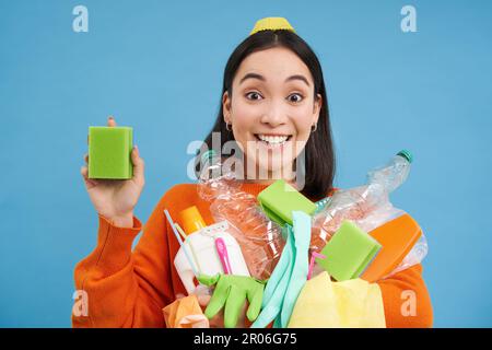 Smiling enthusiastic female eco activist, holding cleaning sponge ...