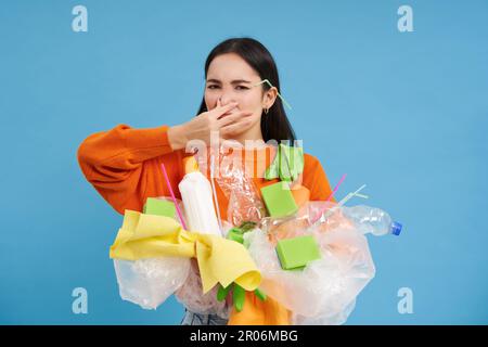 Disgusted asian woman, holds stinky garbage, recycling her waste with ...