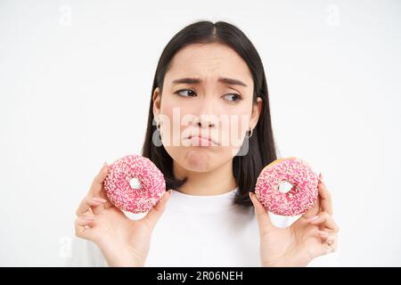 Upset sobbing girl cant eat junk food, shows delicious glazed doughnut ...