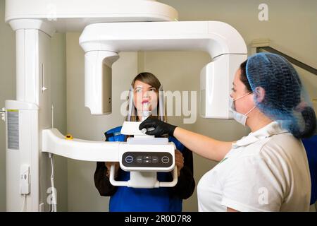 X-ray technician makes CT scan of jaw female patient. Woman making ...