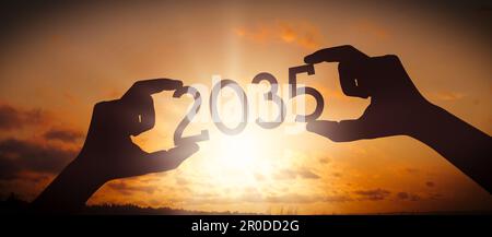 2035 - human hands holding black silhouette year number, gradient ...