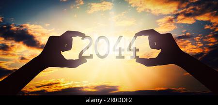 2044 - human hands holding black silhouette year number, gradient ...