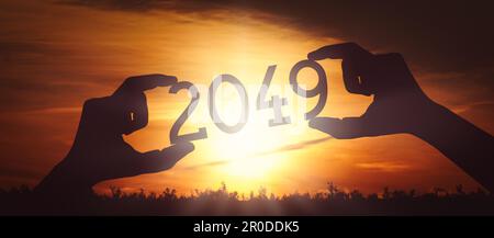 2049 - human hands holding black silhouette year number, gradient ...