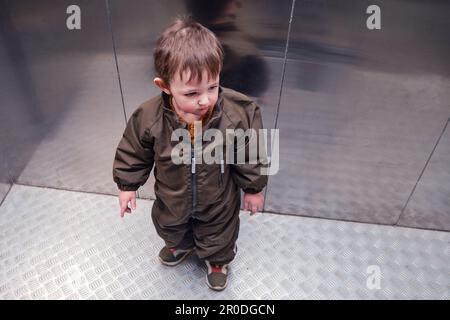 Happy baby rides in the elevator of an apartment building with buttons ...
