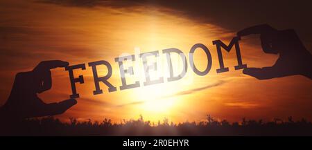 Liberty - human hands holding black silhouette word Stock Photo - Alamy