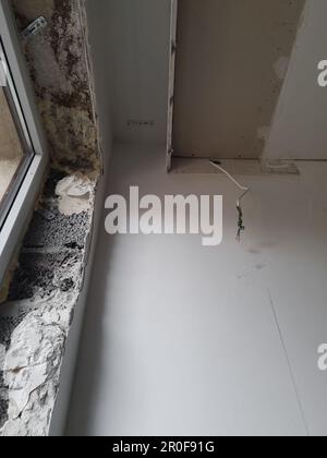 Old mounting foam between a plastic window and a brick wall close-up ...