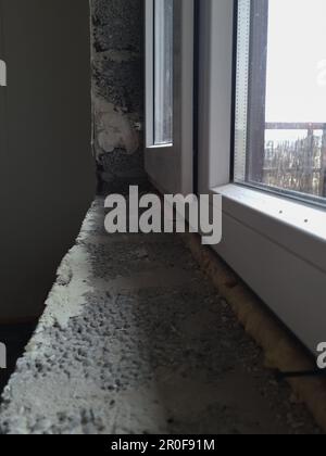 Old mounting foam between a plastic window and a brick wall close-up ...