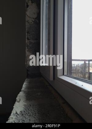 Old mounting foam between a plastic window and a brick wall close-up ...