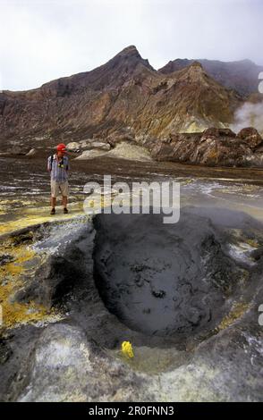 Tourist looking at boiling hot mud on White Island, North Island, New ...