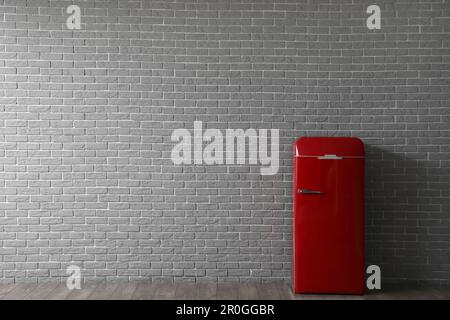 Stylish refrigerator near brick wall in kitchen, closeup Stock Photo ...