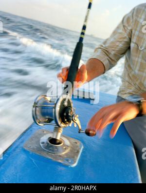 Man preparing for fishing while sitting on snow covered field Stock ...