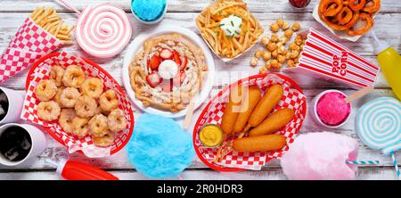 Carnival theme food table scene over a dark wood banner background ...