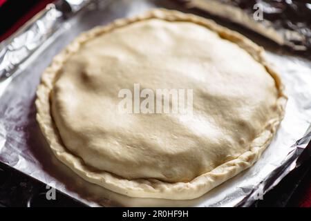 making a closed pie. Round raw pie on a baking sheet. Spread with ...