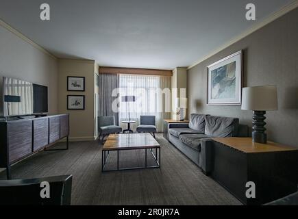 Empty hotel business suite with flat screen tv sofa, wooden table, bar ...