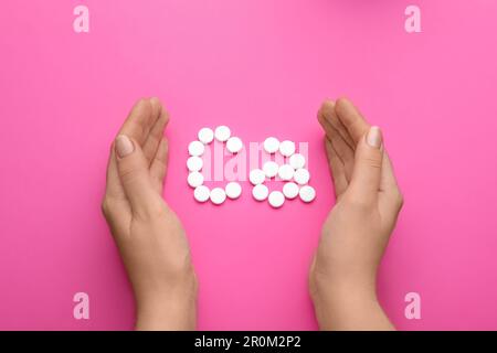 Calcium pills on pink background Stock Photo - Alamy