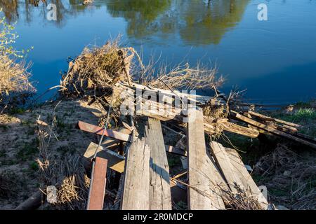 Broken wooden suspension bridge spanning a river in the countryside ...