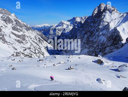 Snowboarder on wild descent, skiing in the White Valley under the ...