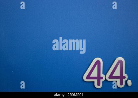 The number 44, placed on a blue background, photographed from above ...