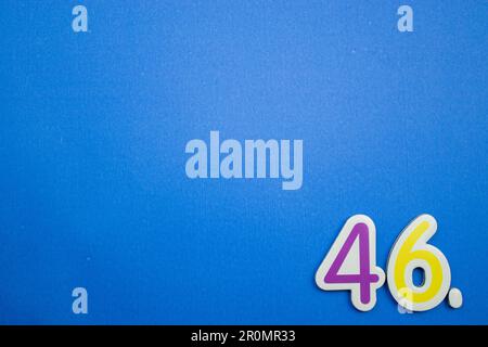 The number 46, placed on a blue background, photographed from above ...
