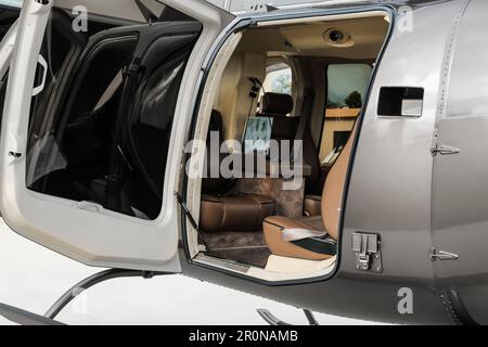 New helicopter with open cabin doors on helipad outdoors Stock Photo ...