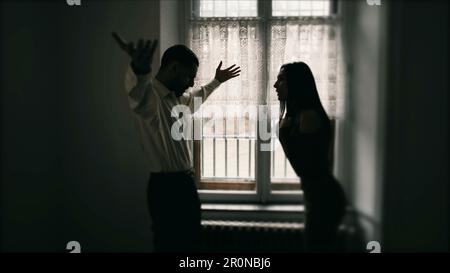 Silhouette of couple fighting each other, arguing and yelling at one ...